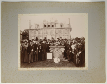 A large group of people gathered around a wellhead in front of the ...