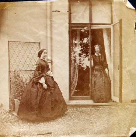Two ladies in dark crinoline dresses by French doors. 801646 | National ...